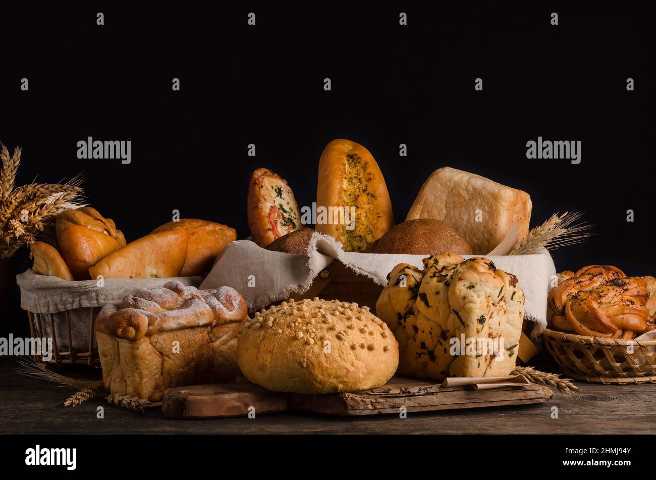 Still life of a varied assortment of breads on a black background ...