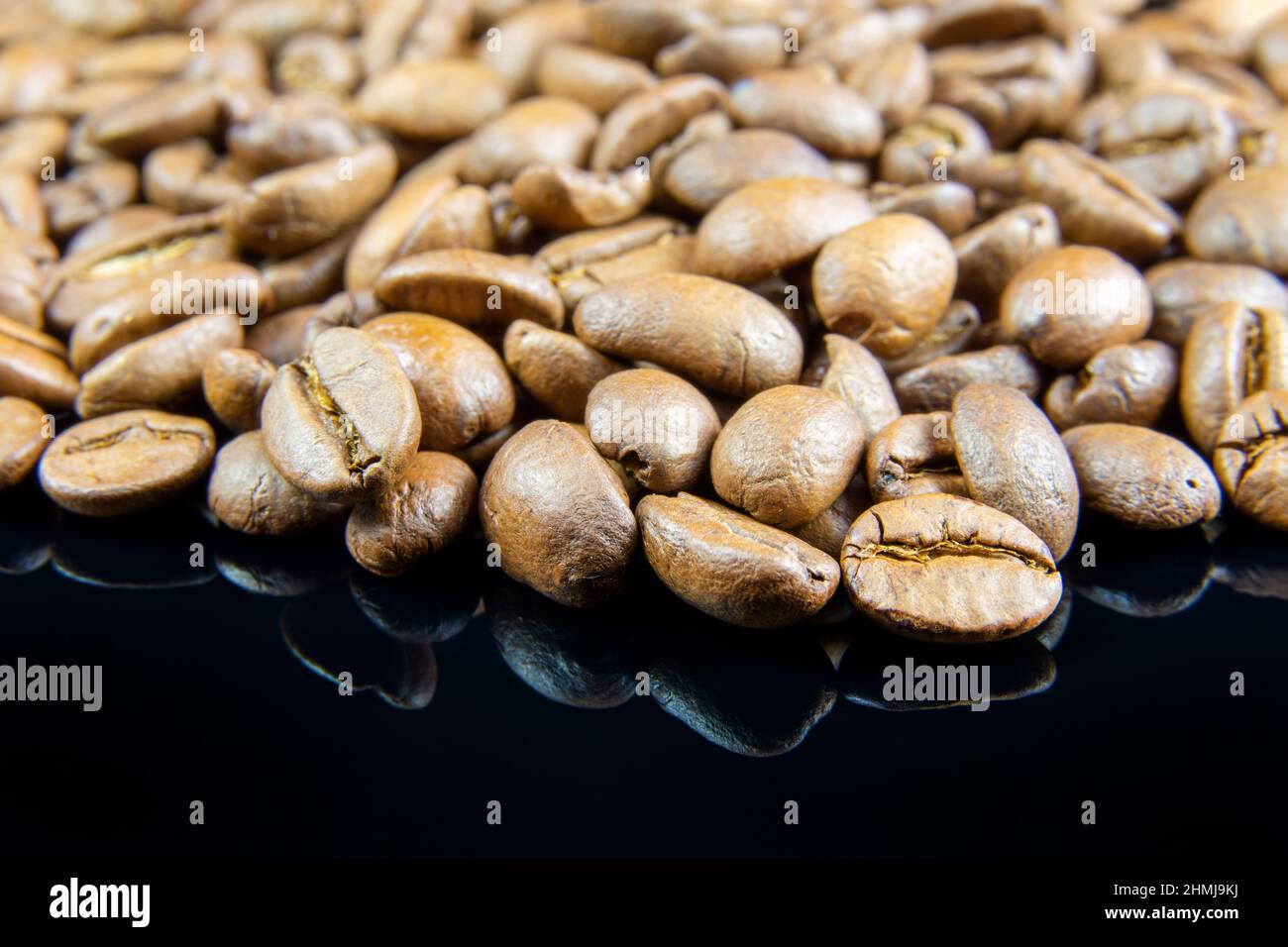 A close up of coffee beans on reflective black background Stock Photo ...