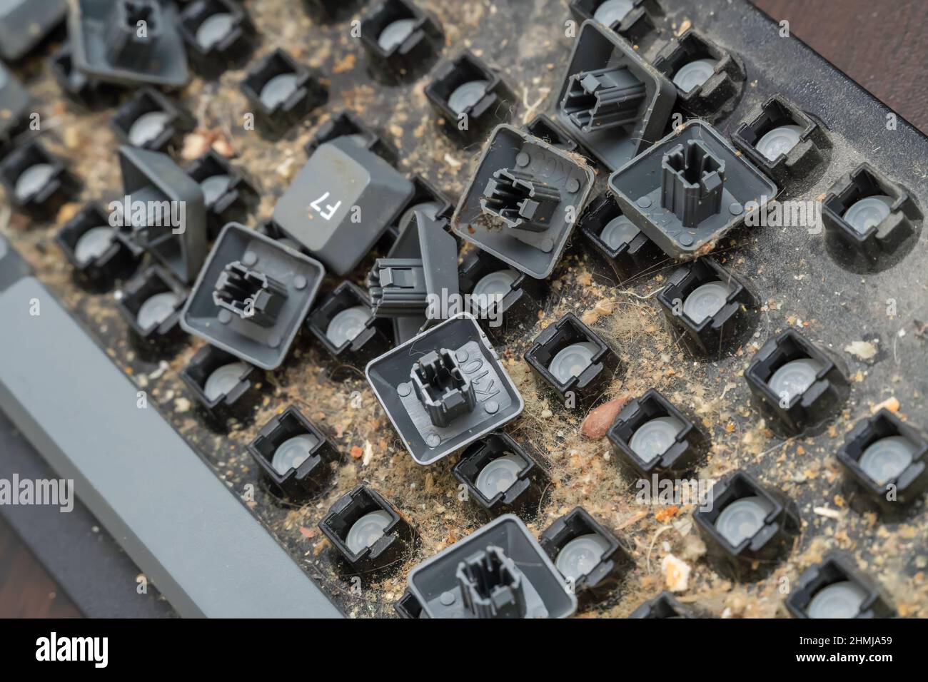 Close-up of a very dirty disassembled computer keyboard on the table ...