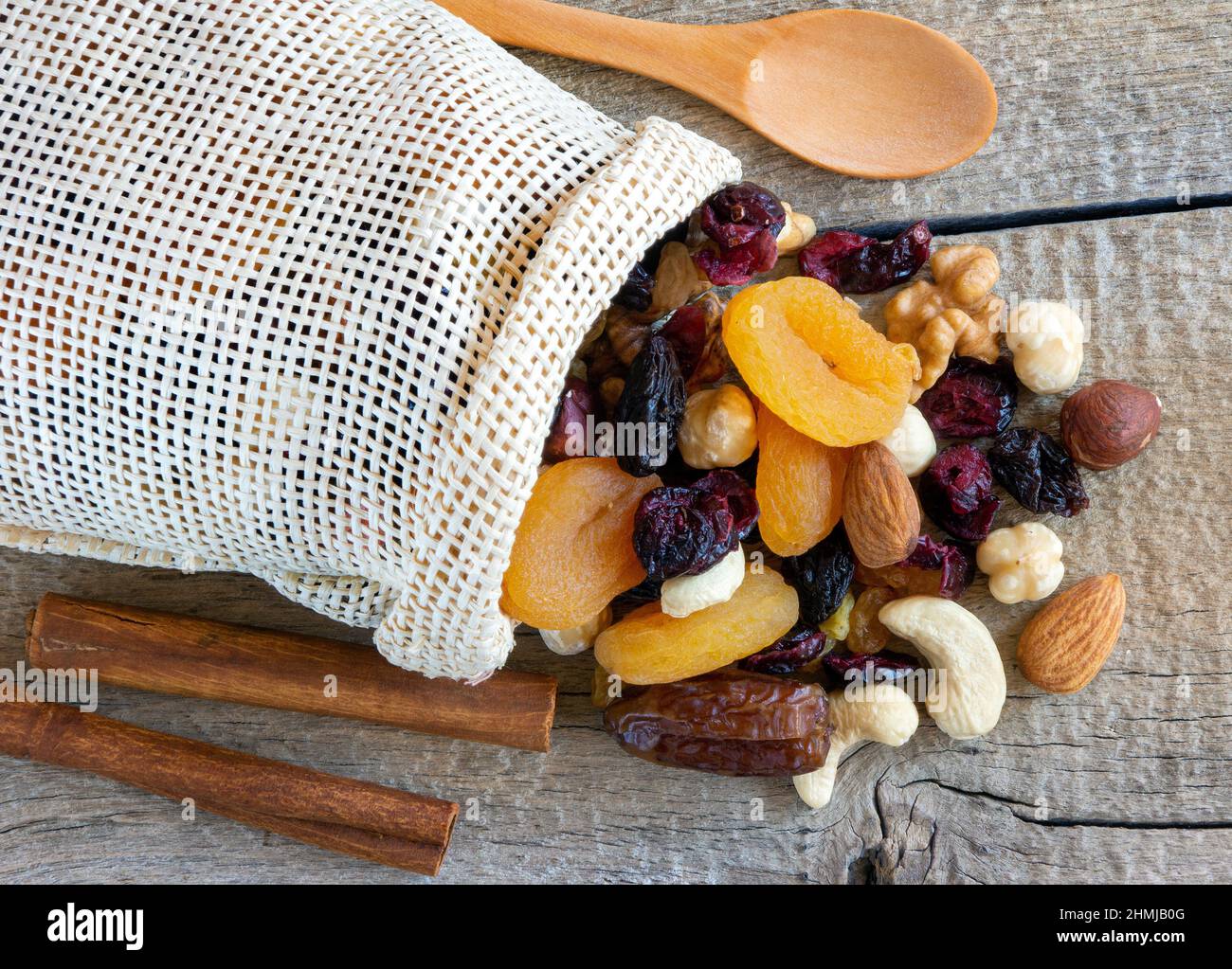 Dried fruits and nuts in a sack on wooden background Stock Photo - Alamy