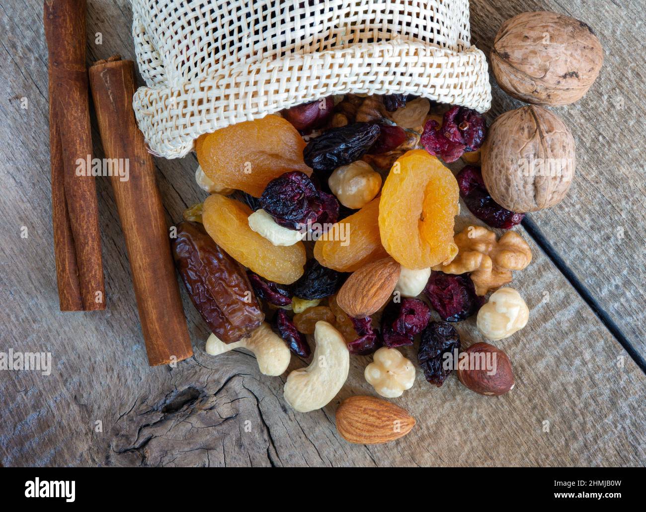 Dried fruits and nuts in a sack on wooden background Stock Photo - Alamy