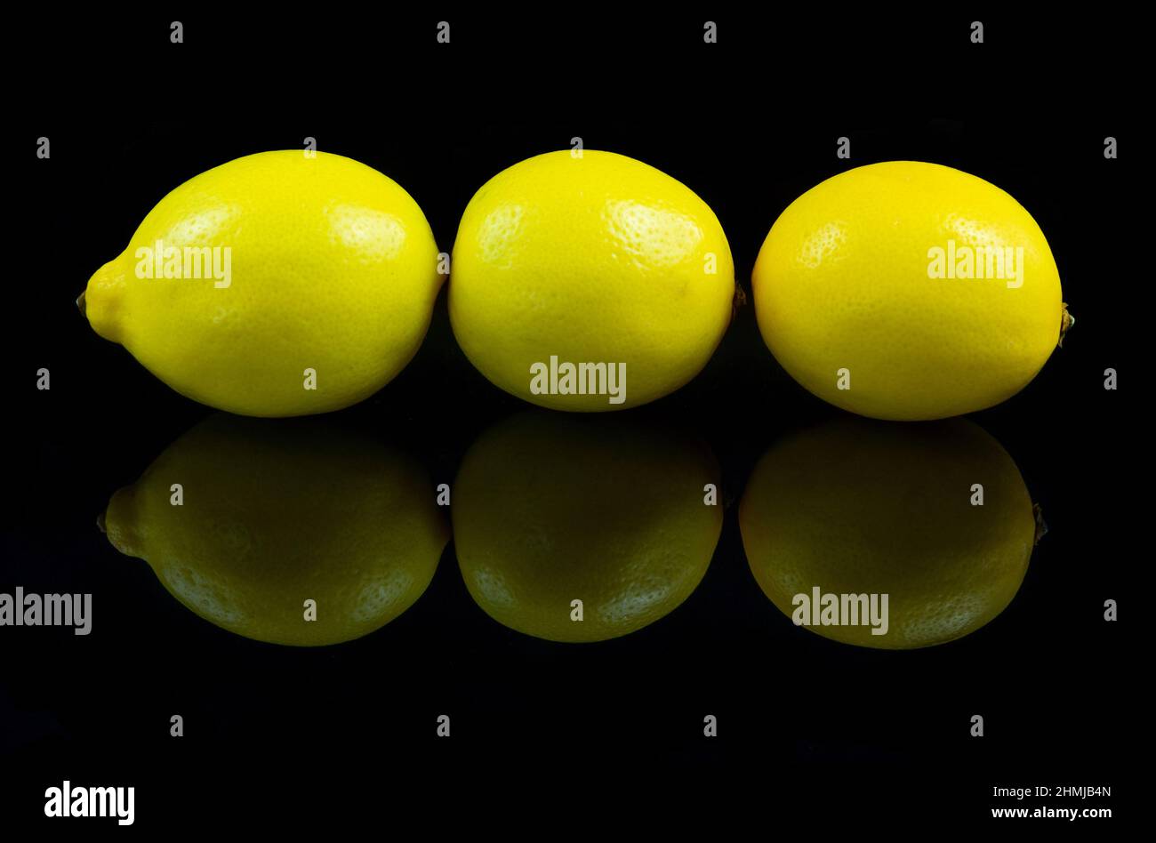 Lemons on reflective black studio background Stock Photo - Alamy