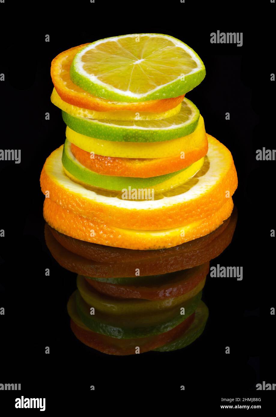 Cuts of different citric fruits on black background Stock Photo - Alamy