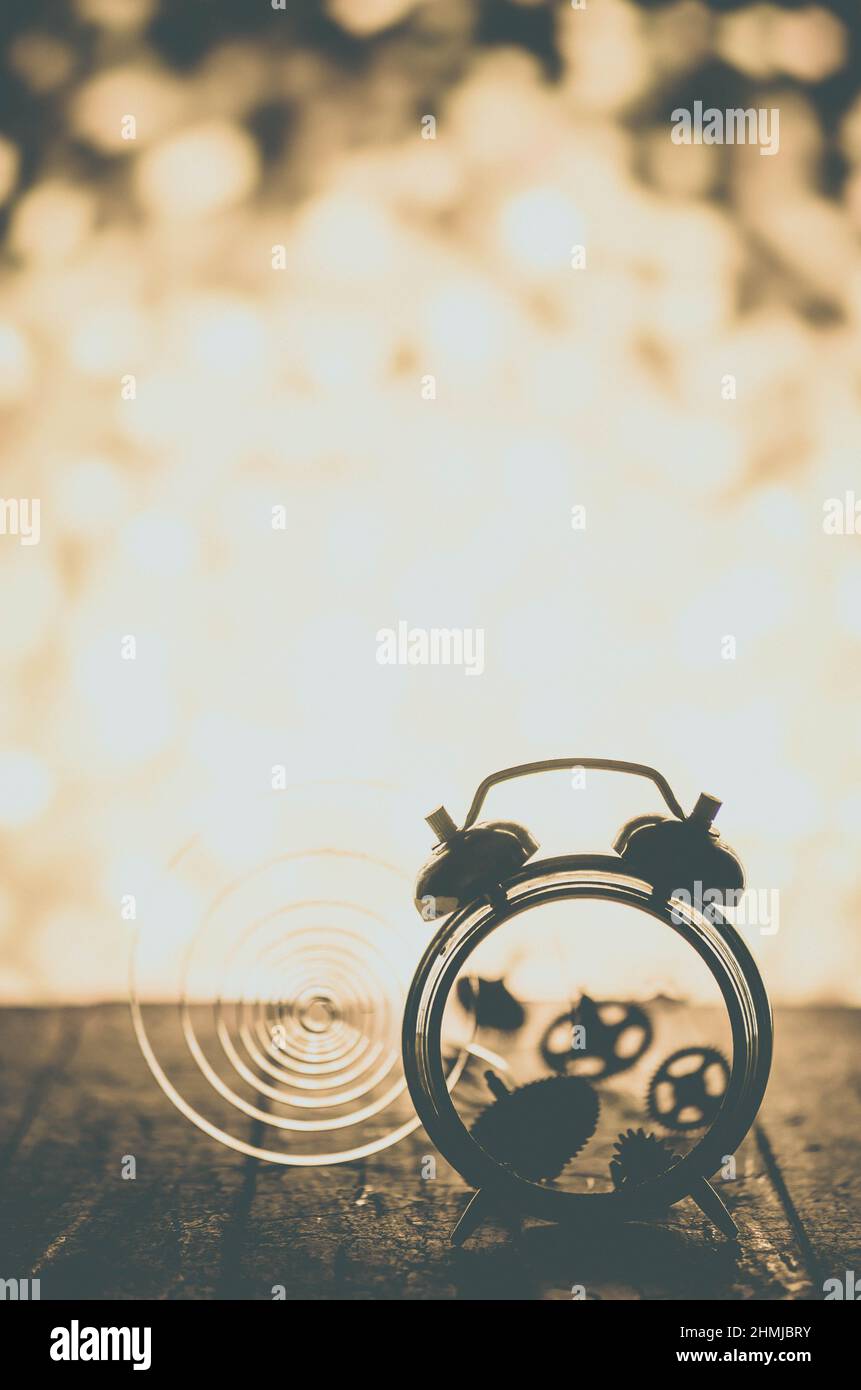 Broken alarm clock with springs and gears scattered on the background ...