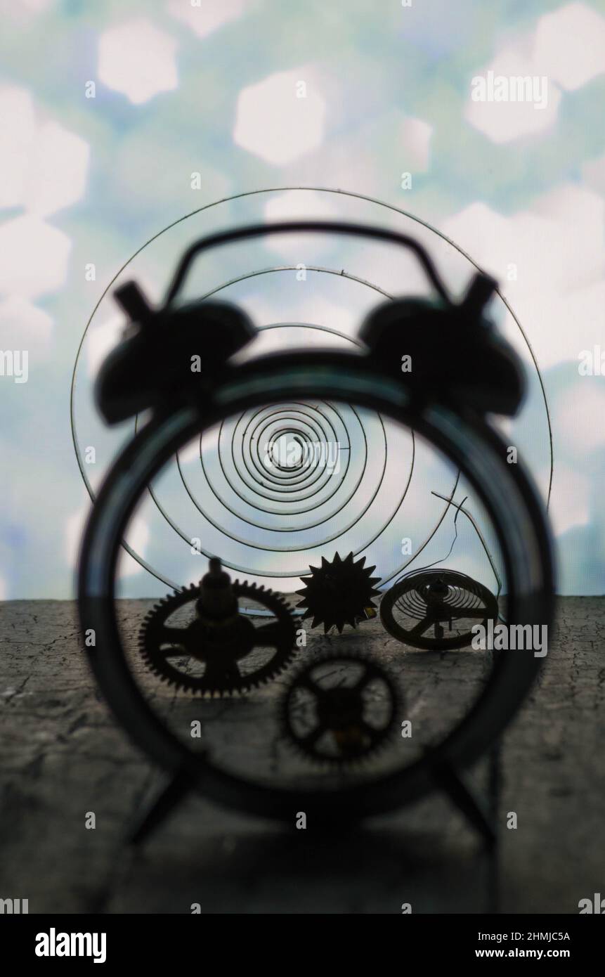 Broken alarm clock with springs and gears scattered on the background ...