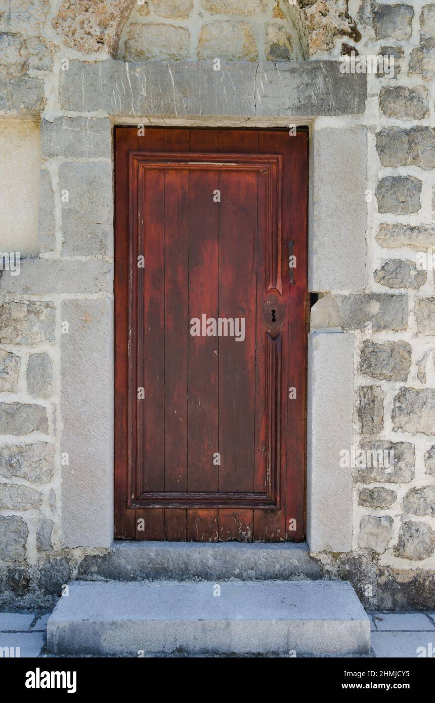 Old wooden door, arched stone wall.Rustic and retro style close-up ...
