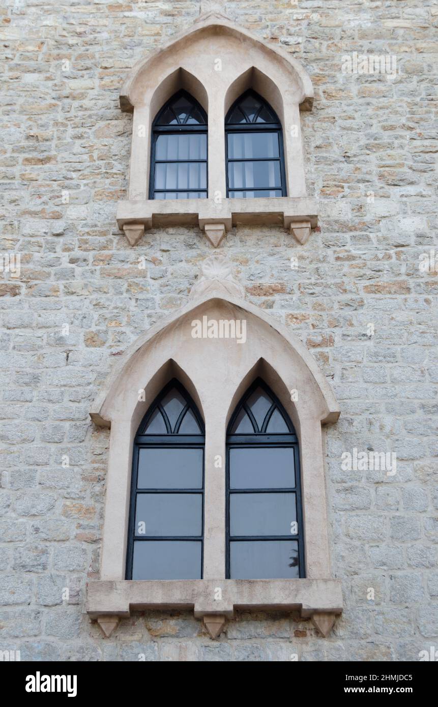 Old Gothic Windows in the shape of a peak in a stone building close-up ...