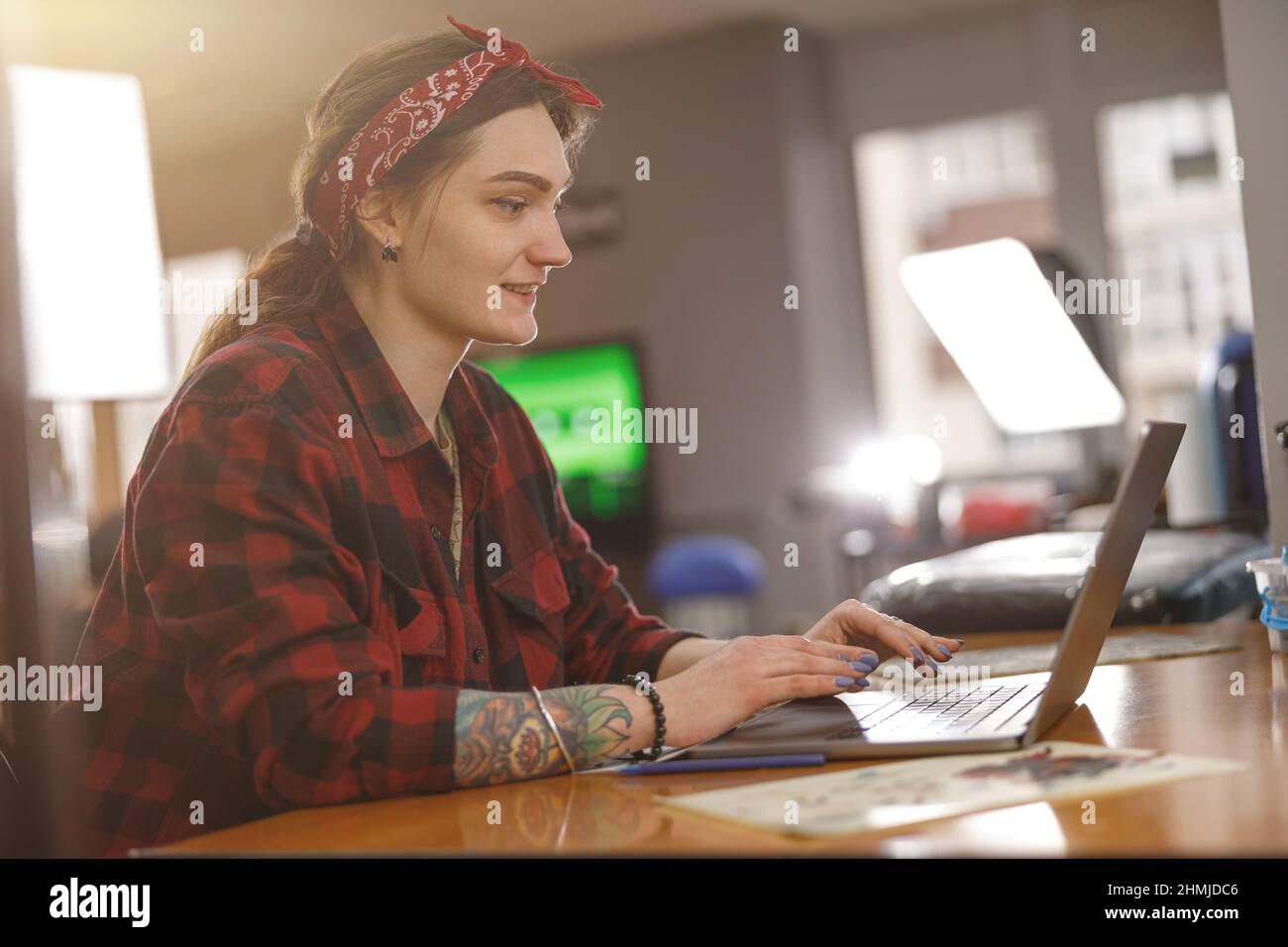 Tattoo artist working on laptop in office Stock Photo - Alamy