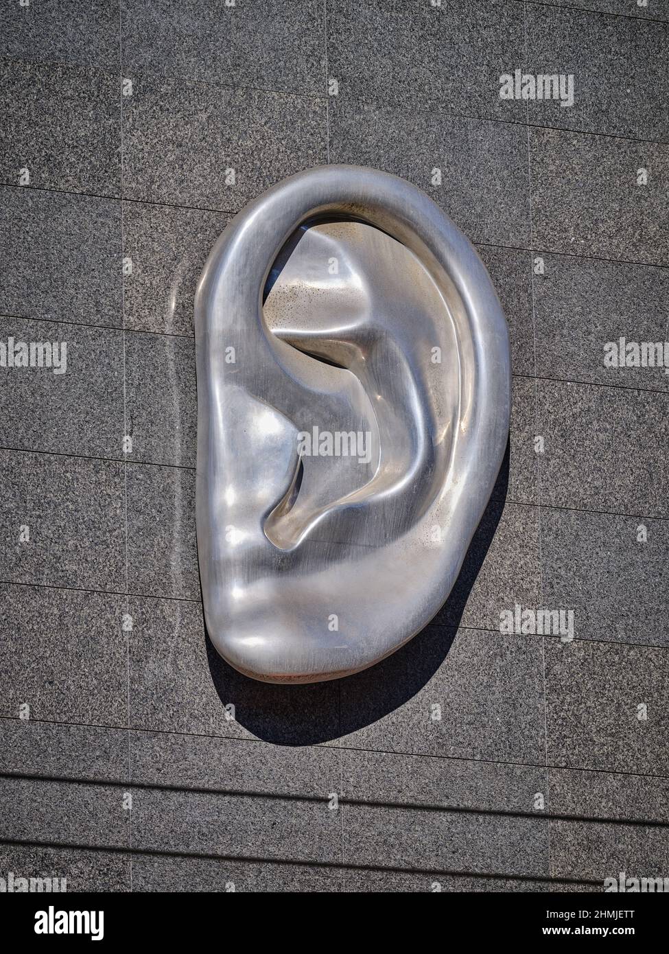Large metal ear on the granite facade of the house, Bratislava ...
