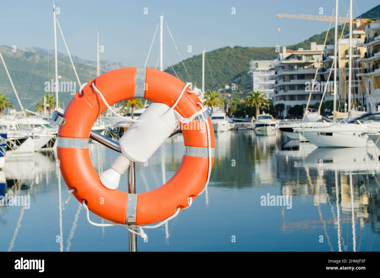 Orange lifebuoy in the port on background of yachts and boats.On a ...