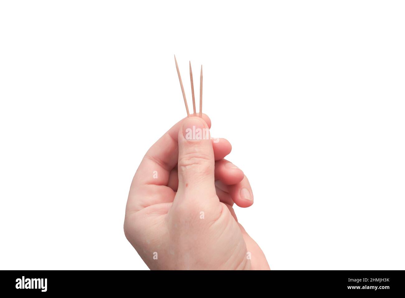 A man's hand with close-up toothpicks. Three sharp wooden sticks in his ...