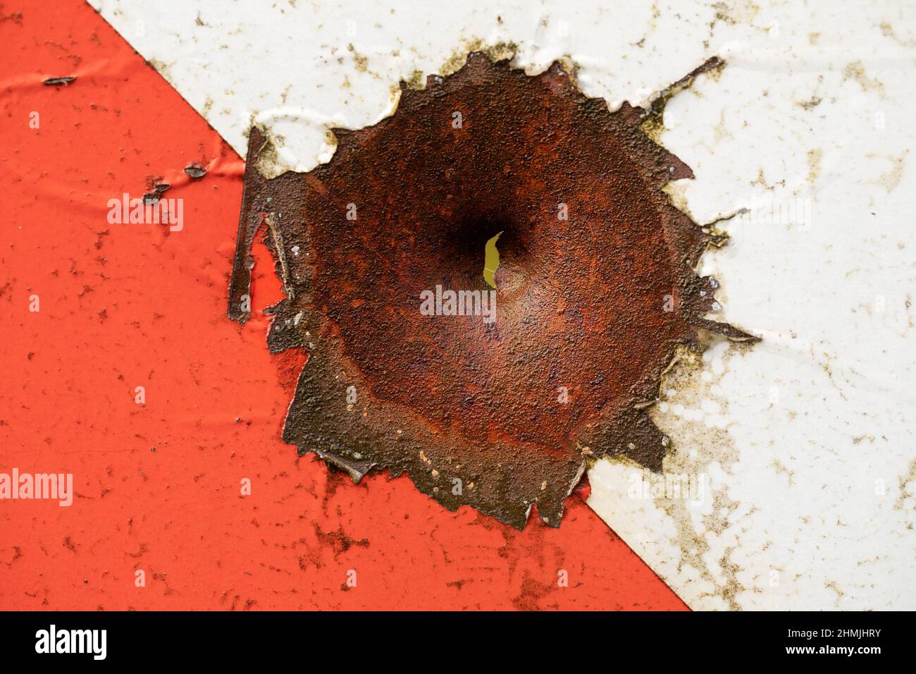 Bullet hole in old metal painted red. Abstract background Stock Photo ...