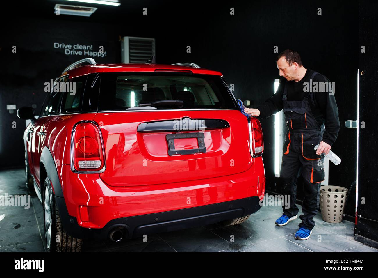 Man worker washing red car in detailing garage Stock Photo - Alamy