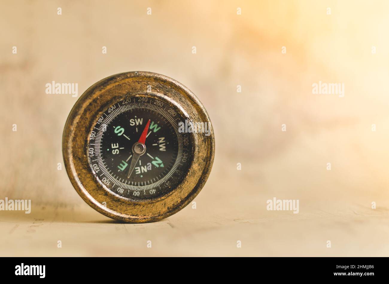Compass on old map background with falling sun ray on it Stock Photo ...