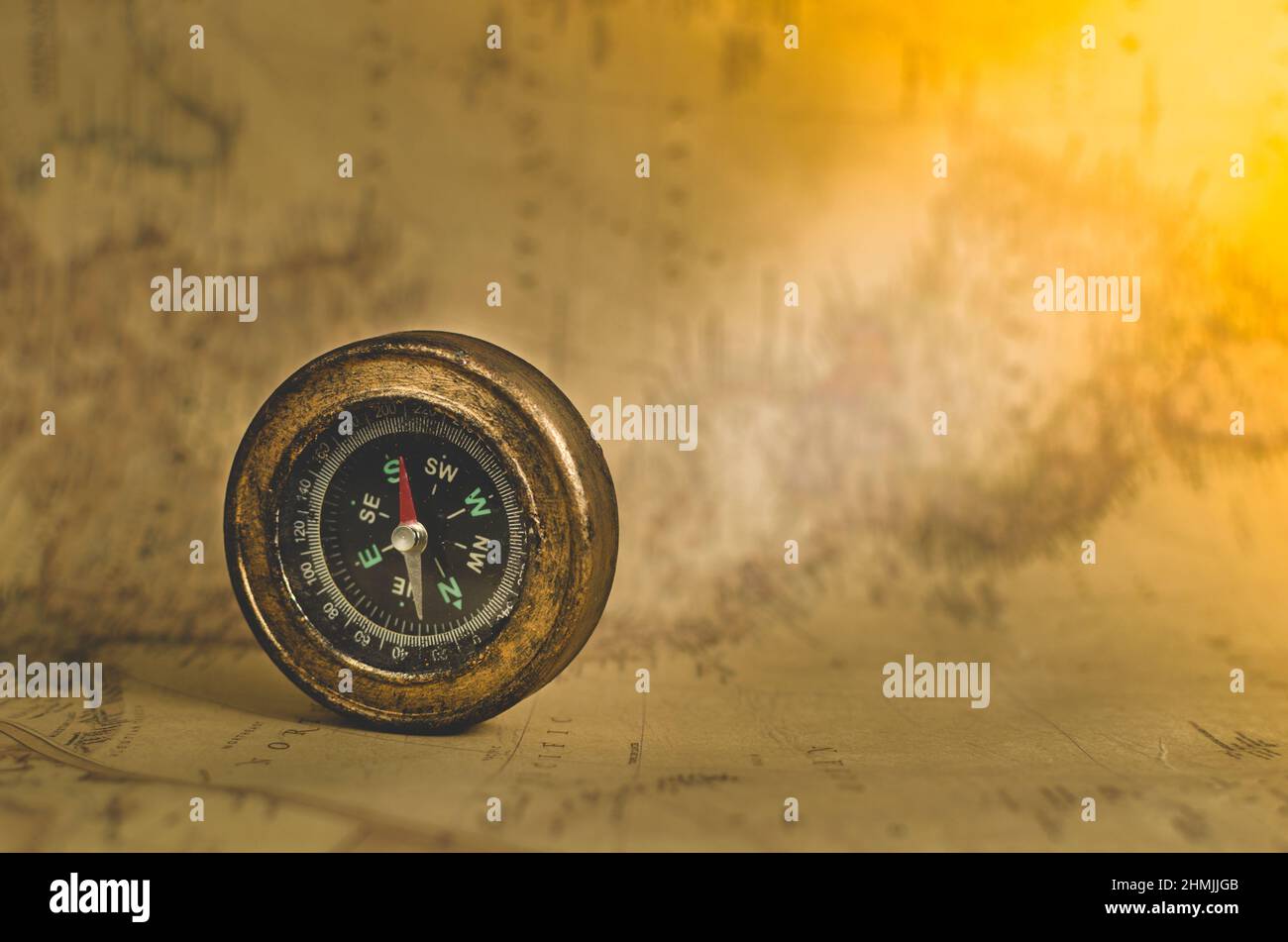 Compass on old map background with falling sun ray on it Stock Photo ...
