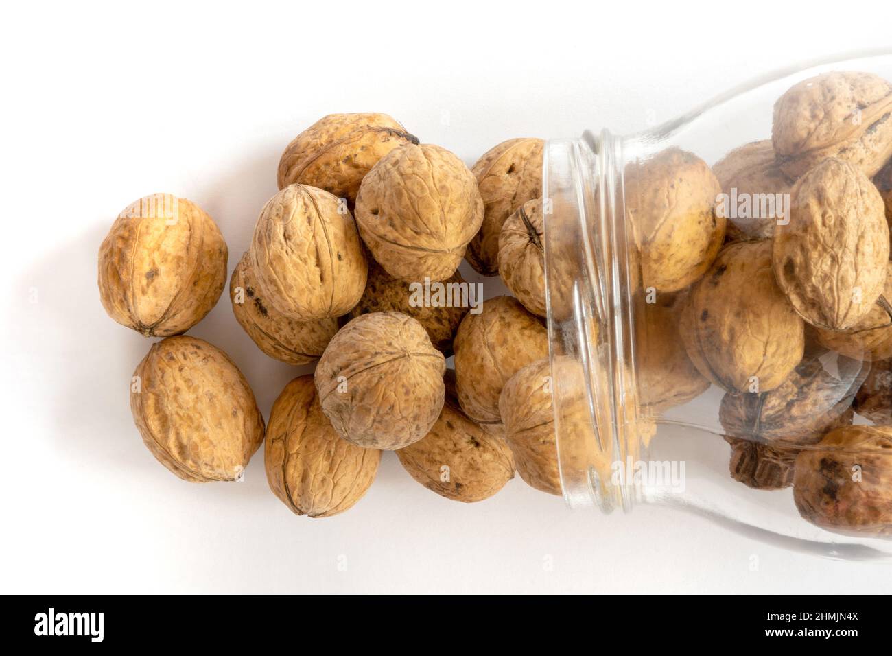 Whole solid walnuts in a jar on white background Stock Photo - Alamy