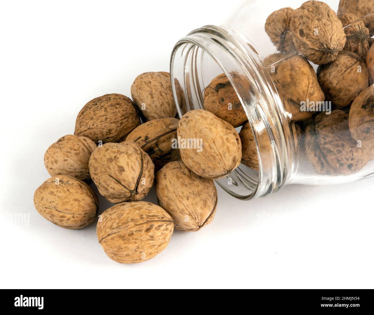 Whole solid walnuts in a jar on white background Stock Photo - Alamy