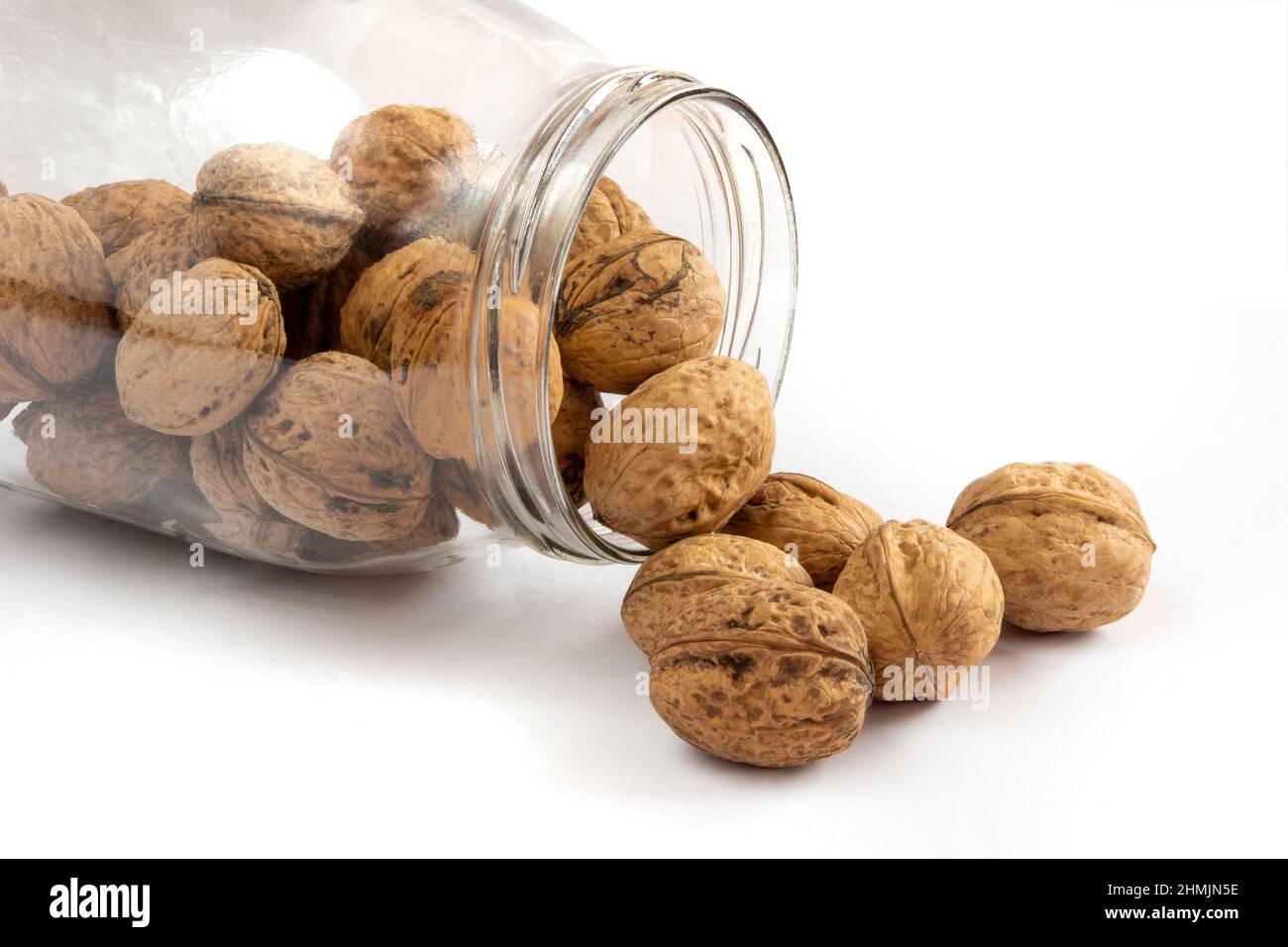 Whole solid walnuts in a jar on white background Stock Photo - Alamy