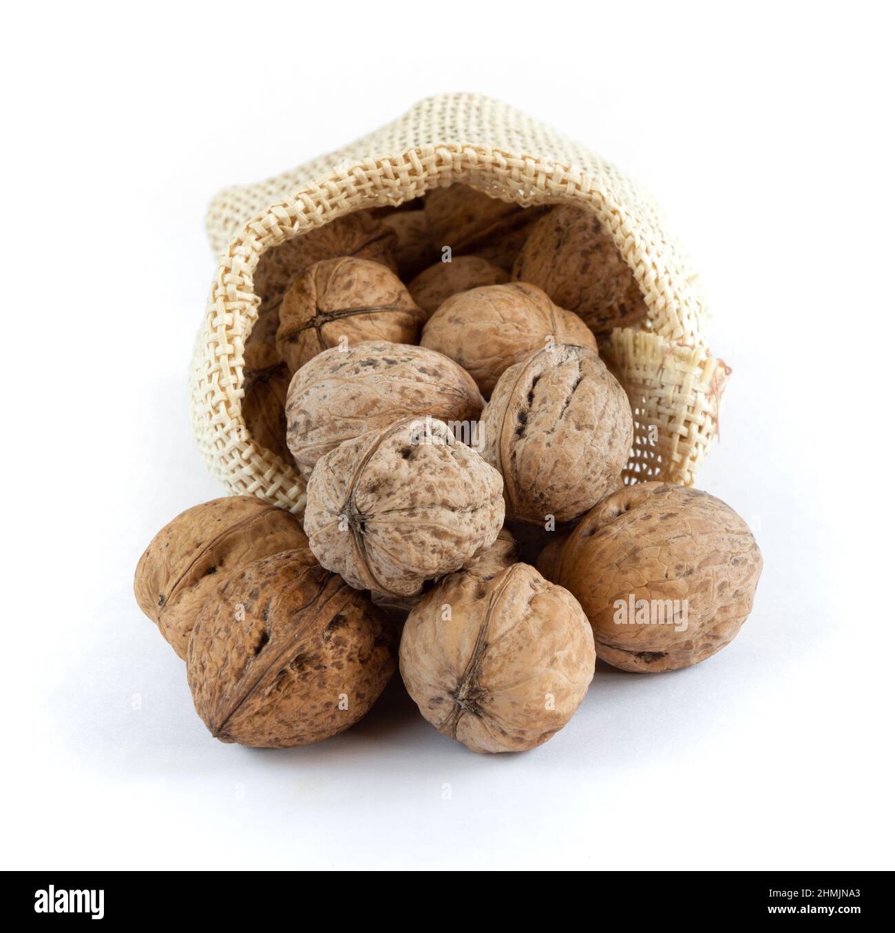 Walnuts in a sack on white background Stock Photo - Alamy
