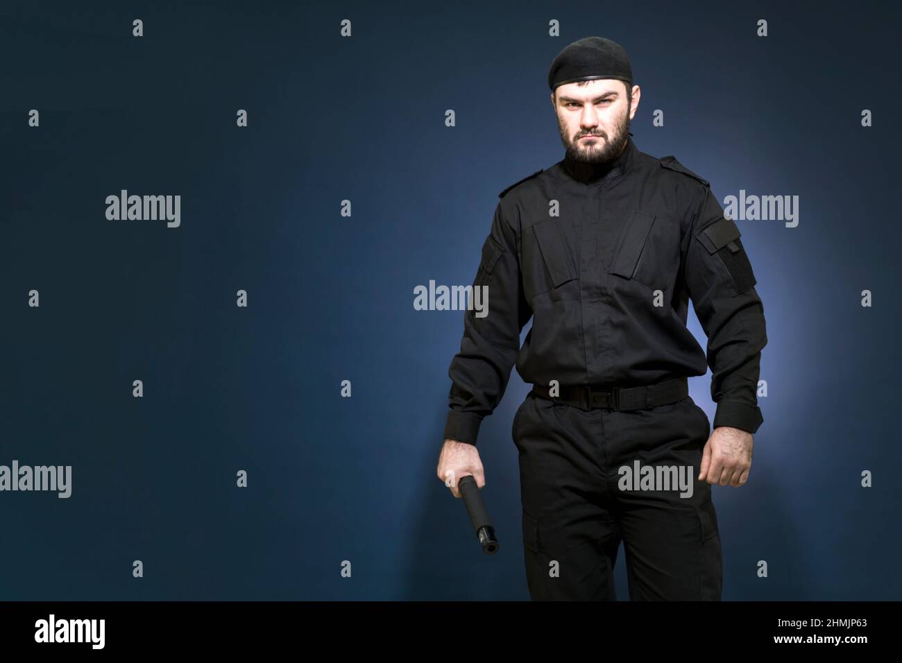 Bodyguard. A male security guard in a black uniform and a cap took a ...