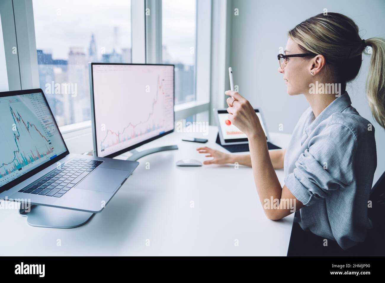 Female broker studying diagram on computer screen at work Stock Photo ...