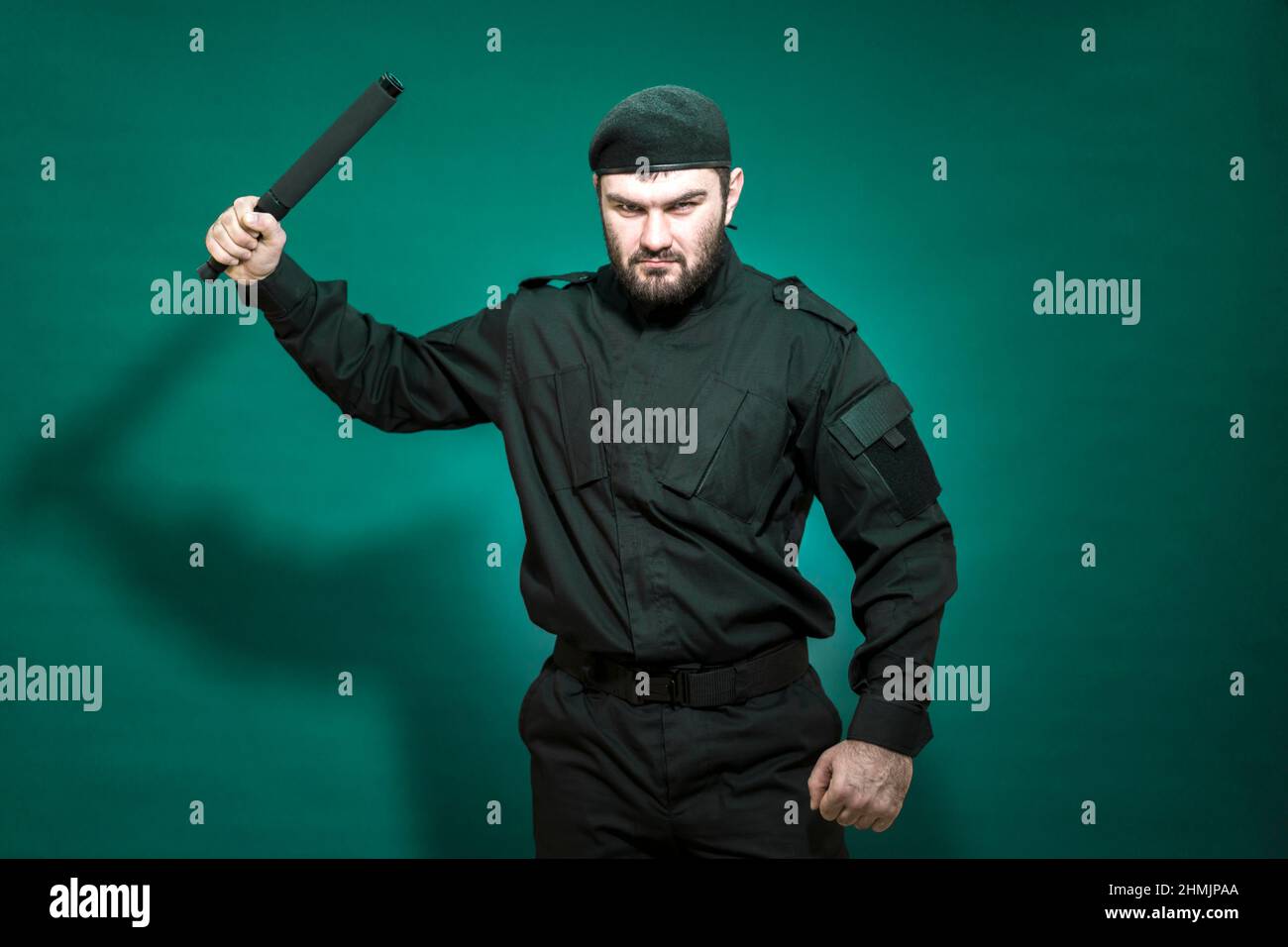 A male guard in black uniform and a cap took up a defensive position ...