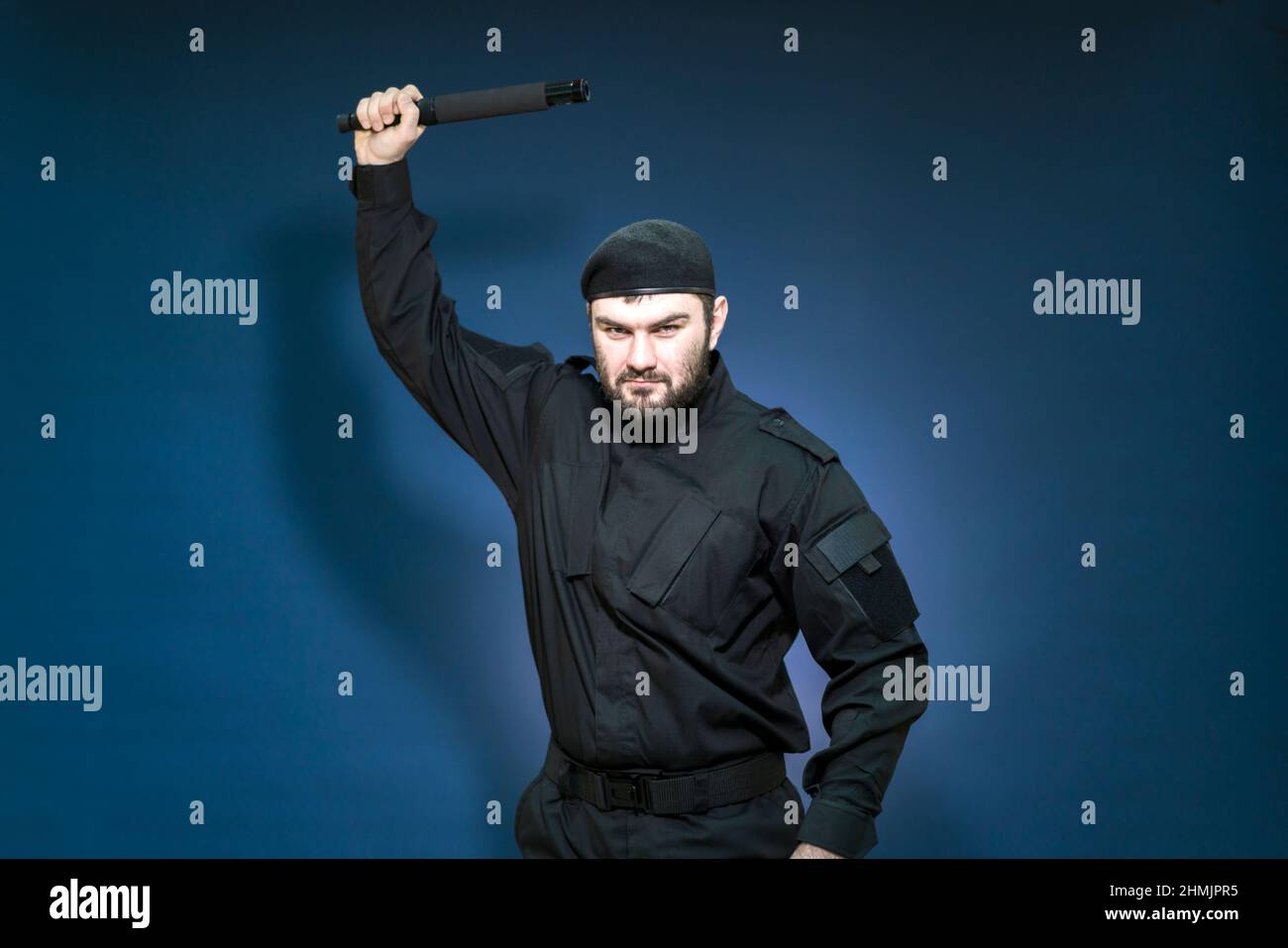 Private security. A male guard in black uniform and a cap took up a ...