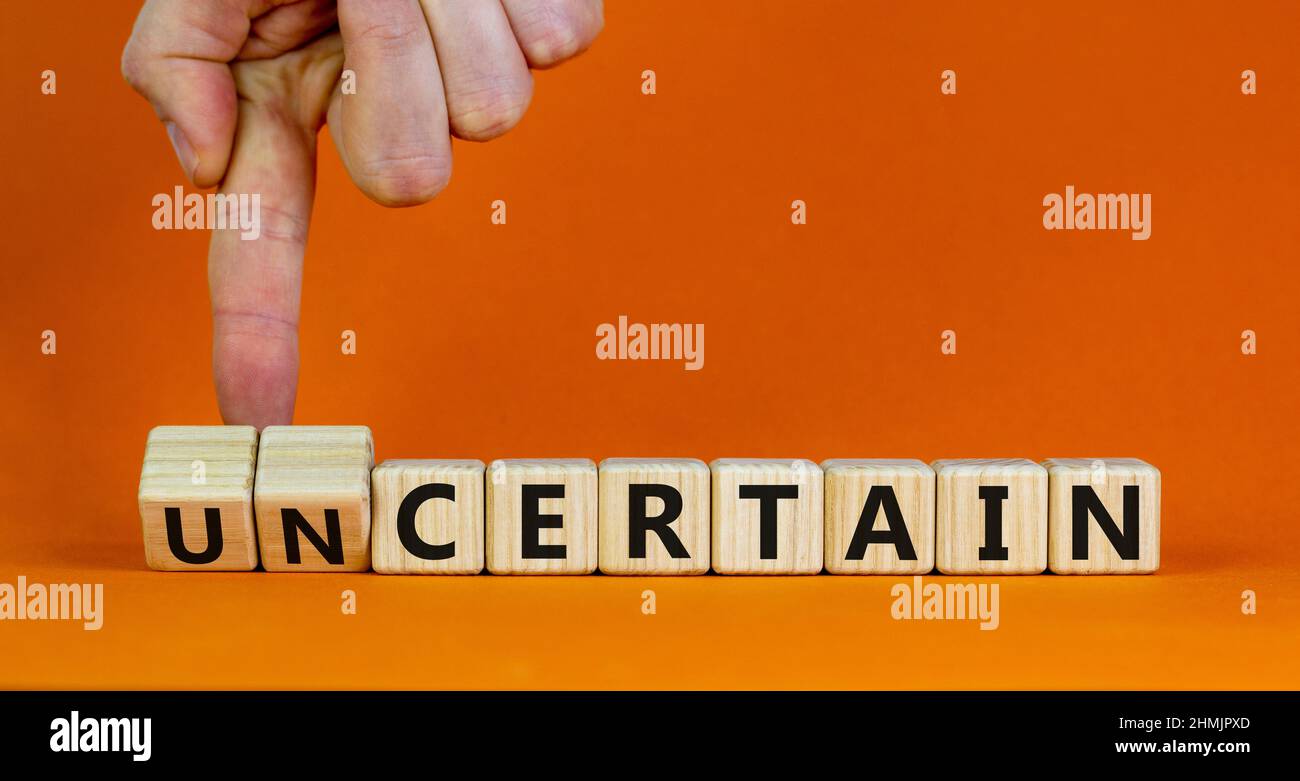 Certain or uncertain symbol. Businessman turns wooden cubes and changes ...