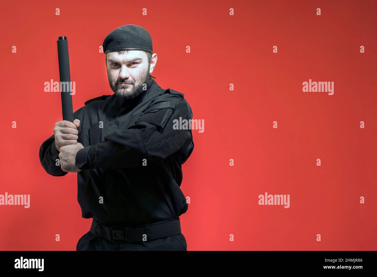 Mercenary. Defender. A male guard in a black uniform and a cap took up ...