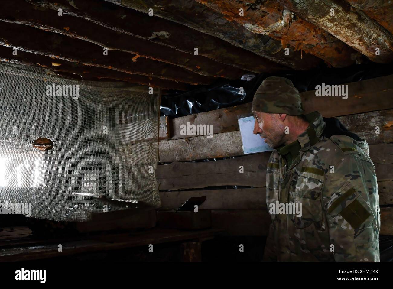 Ukrainian serviceman is seen with a machine gun in a trench shelter ...