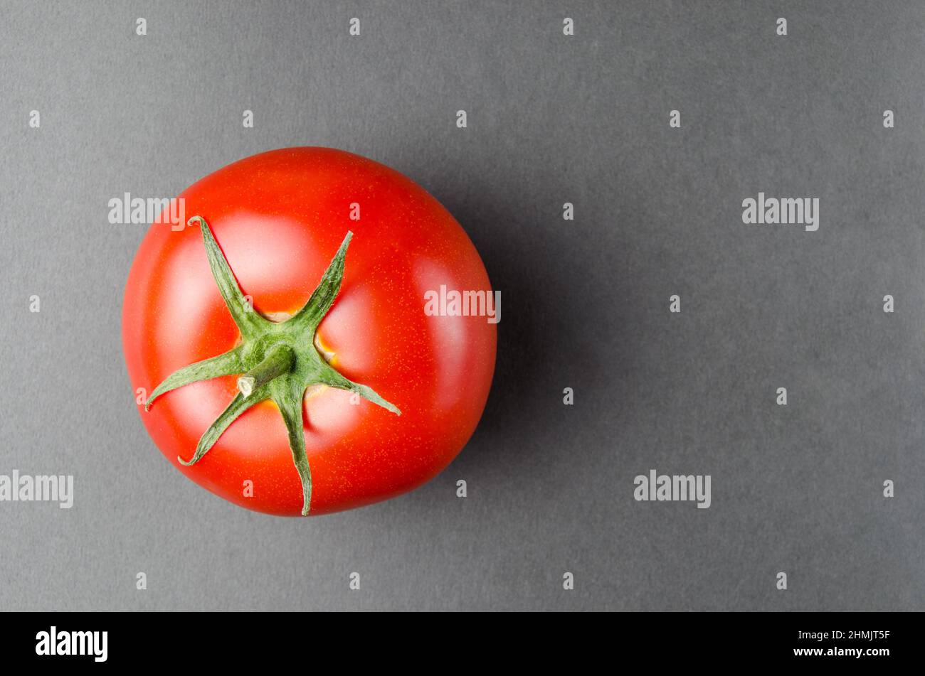 Bright, red and ripe tomato on dark grey background.Close up Stock ...