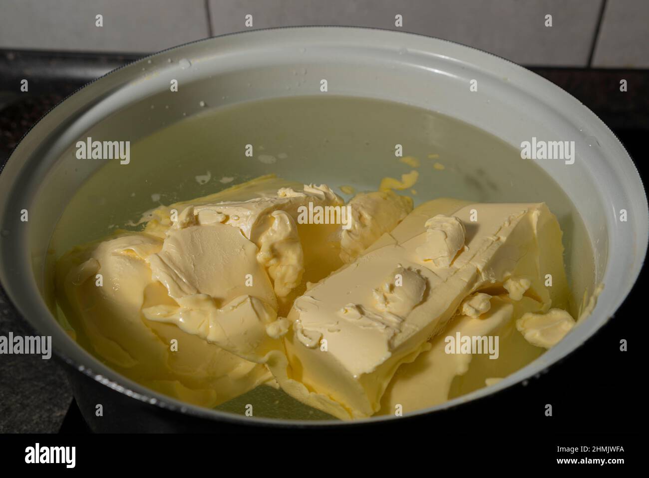 Cooking of yellow and green marijuana medicinal butter in hot water in ...