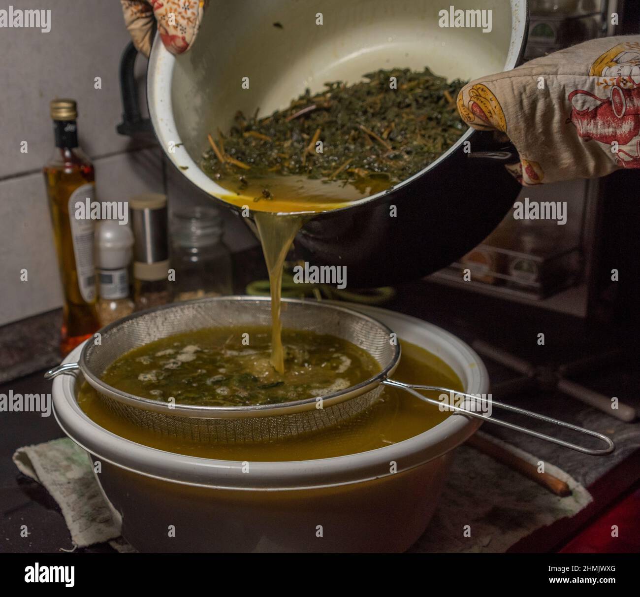 Cooking of yellow and green marijuana medicinal butter in hot water in ...