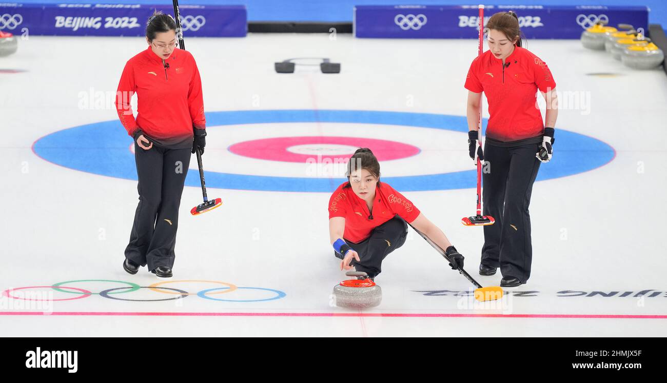 Beijing, China. 10th Feb, 2022. Dong Ziqi (C) of China curls the stone ...