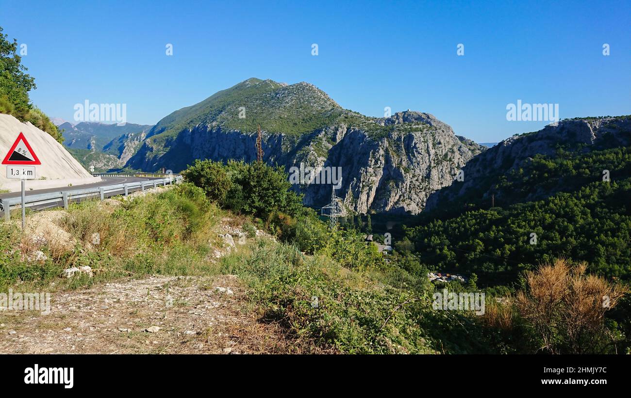 Curving road with a road sign and beautiful mountains Stock Photo - Alamy