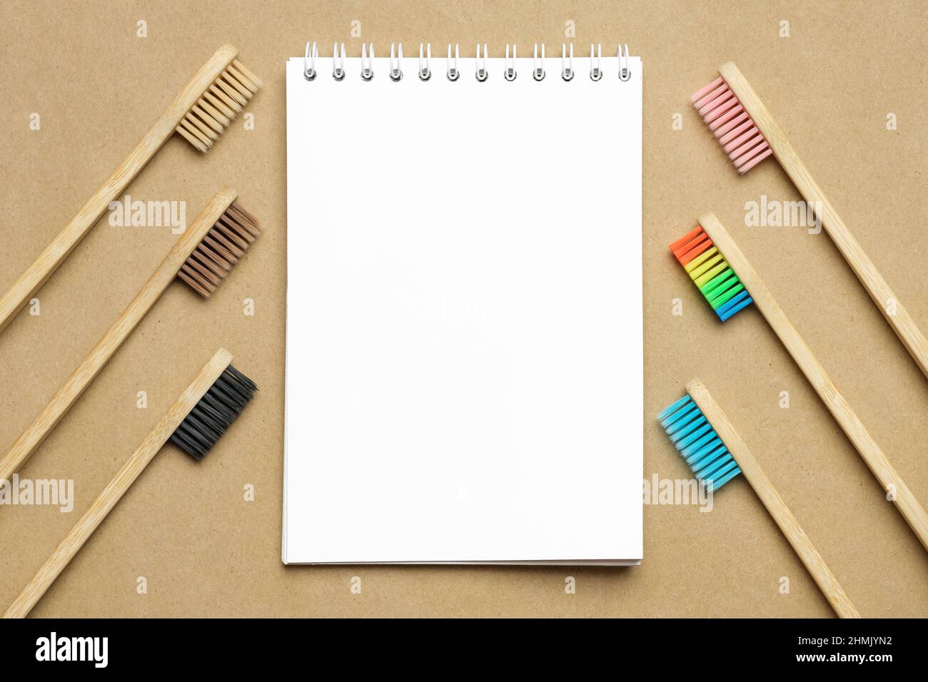 Six bamboo toothbrushes lying on craft brown paper with notepad. Top ...