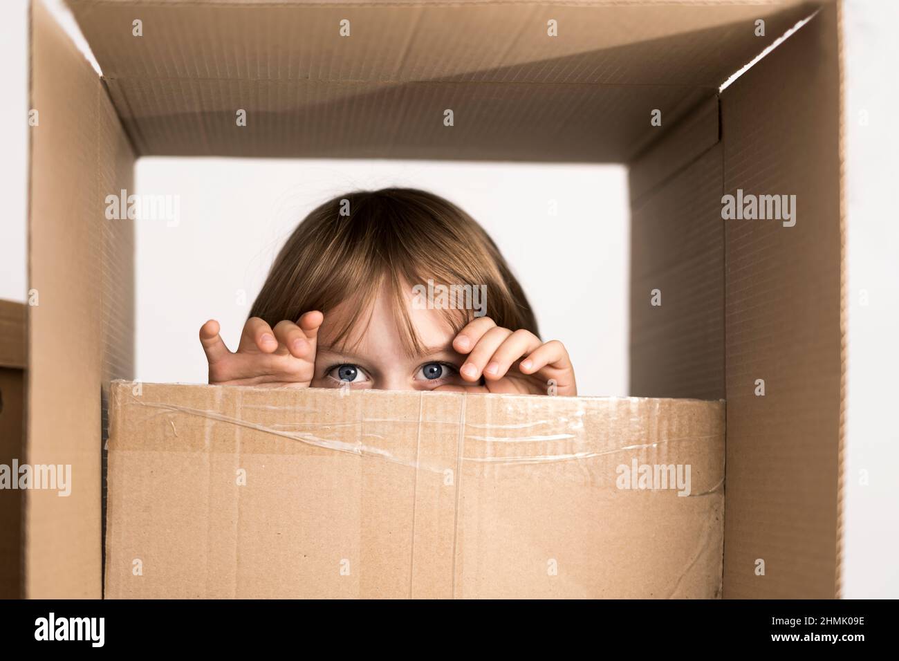 Excited little boy jumping inside a huge cardboard box. He is playing ...