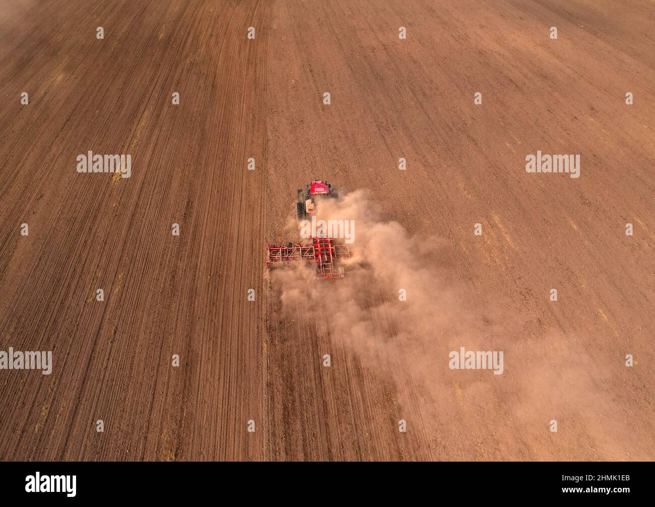 Field cultivating, aerial view. Tractor with disk harrow on plowed ...