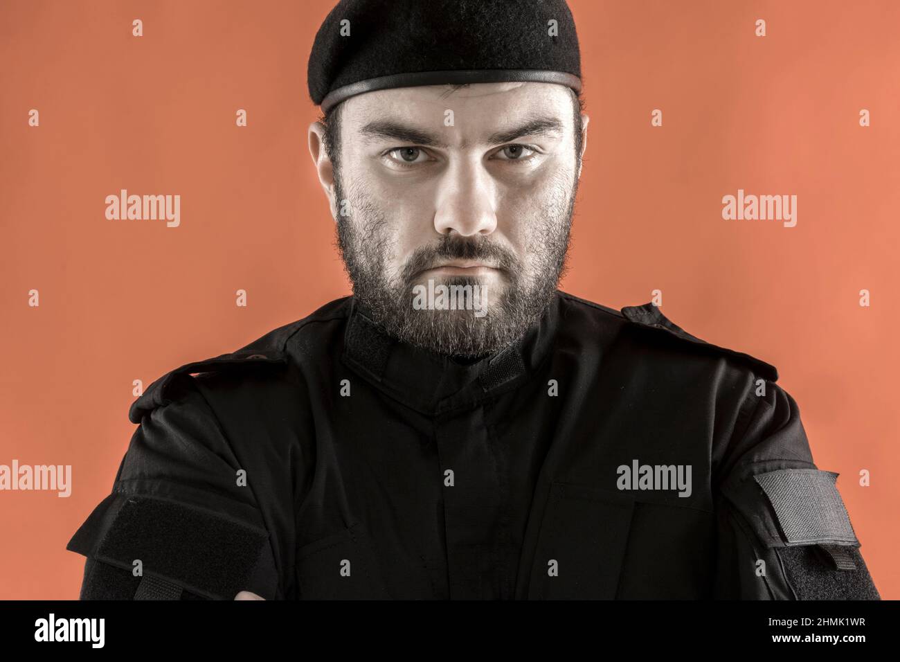 Mercenary. A male security guard in a black uniform and a cap with a ...