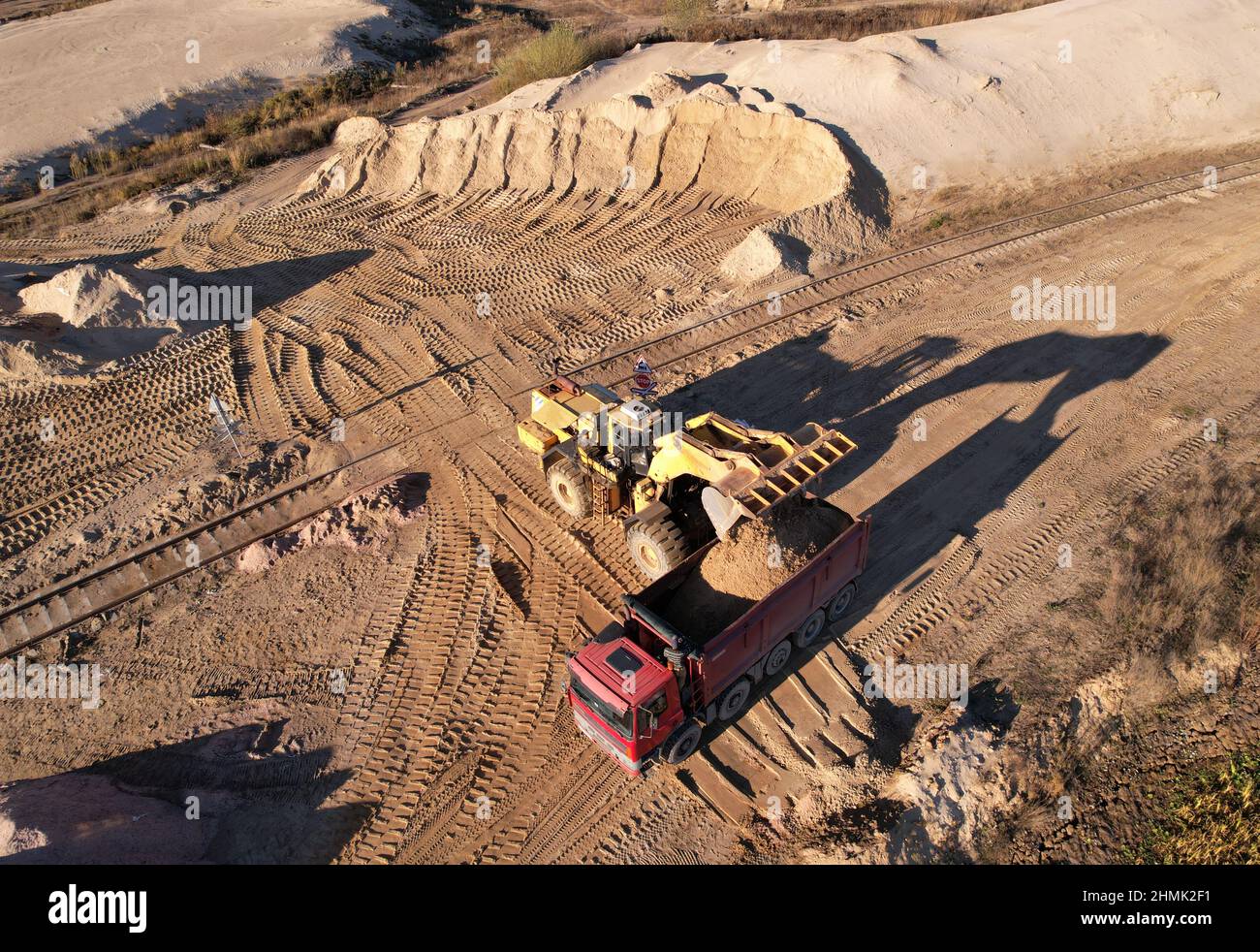 Wheel loader load the sand into dump truck in open pit. Developing the ...