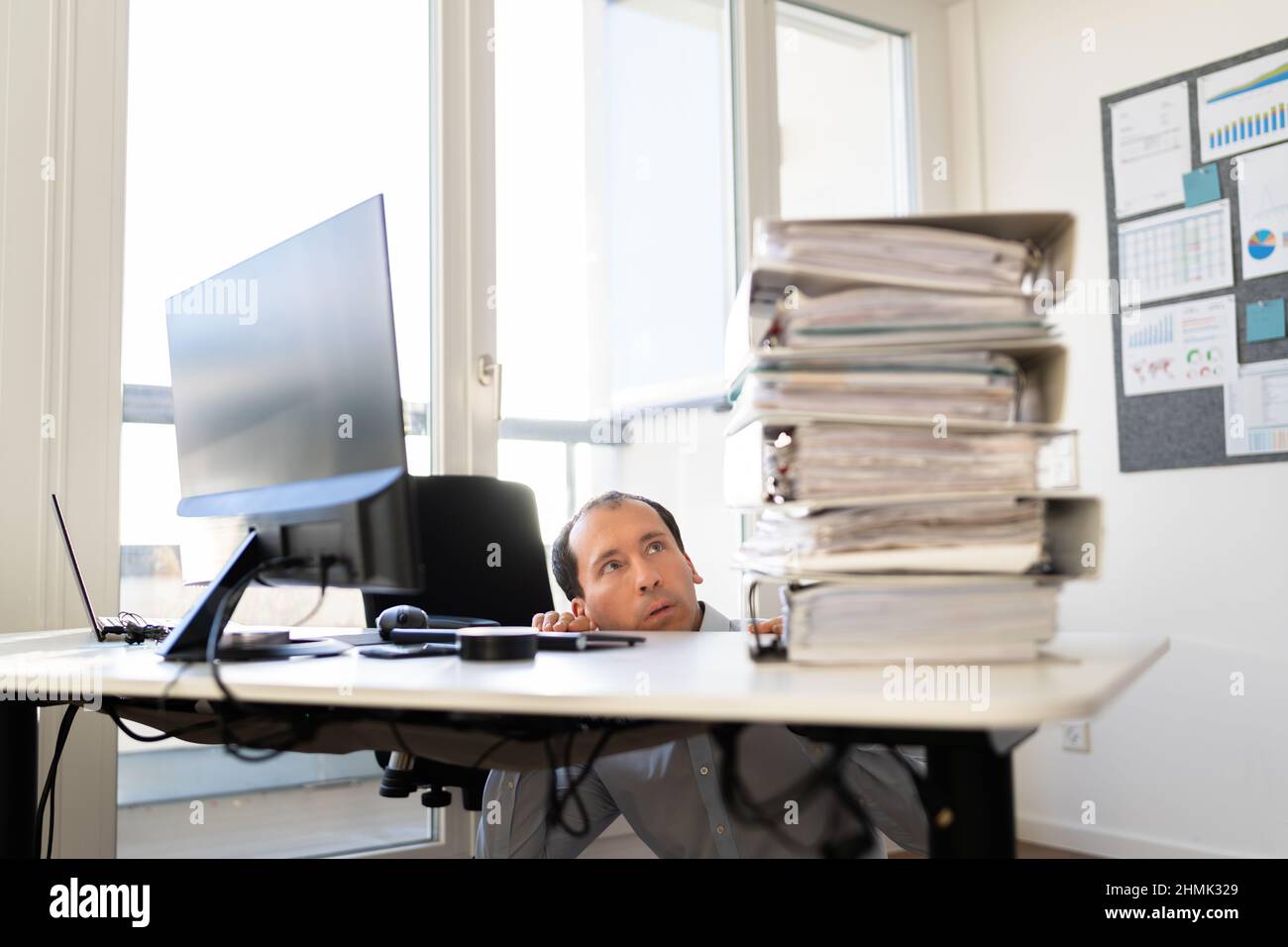 Overworked Business Man With Stack Or Pile Of Folders Stock Photo - Alamy