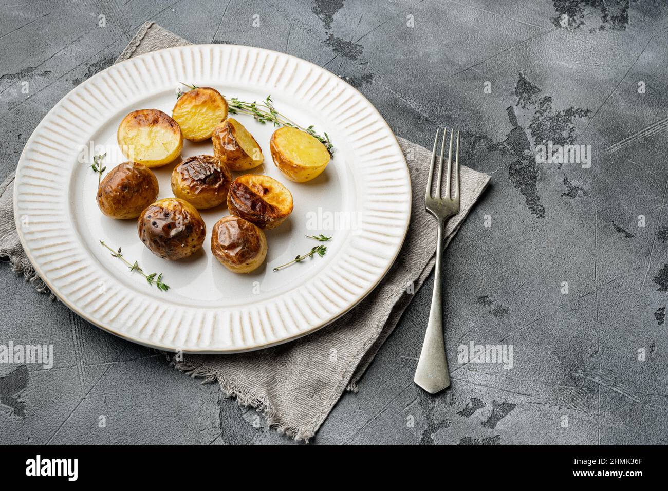 Baked potatoes set, on plate, on gray stone table background, with copy ...