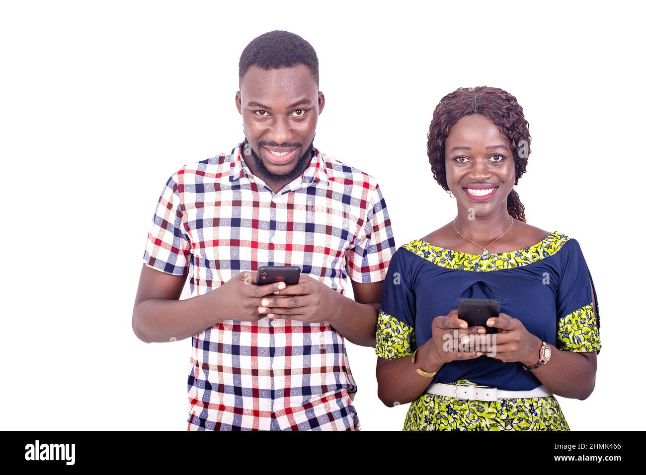 beautiful loving couple each holding a mobile phone at home and smiling ...
