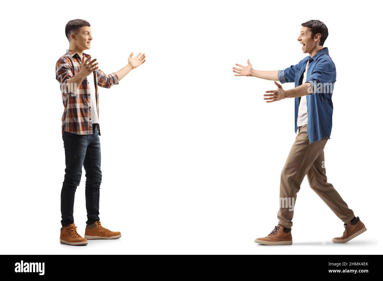 Full length profile shot of two young men walking towards each other ...