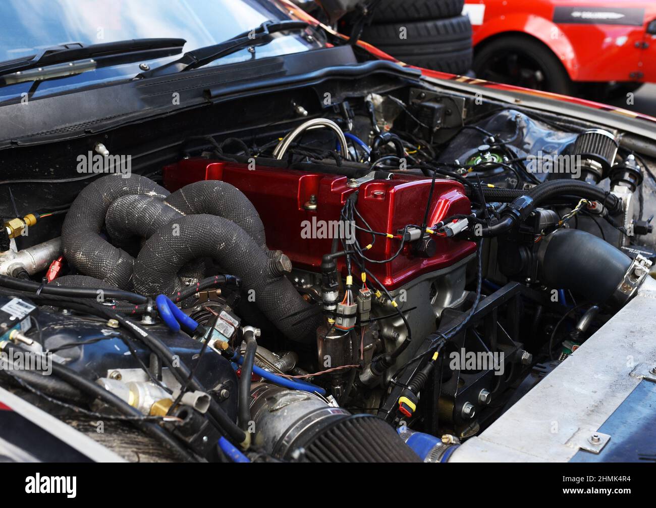 Sports car engine with turbine. An open race car hood on a pit stop ...
