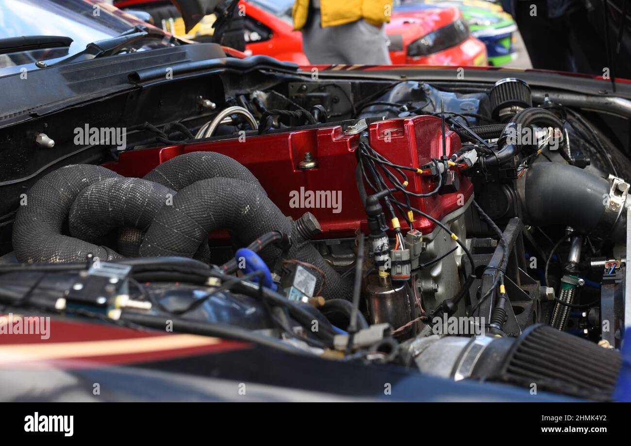 Sports car engine with turbine. An open race car hood on a pit stop ...