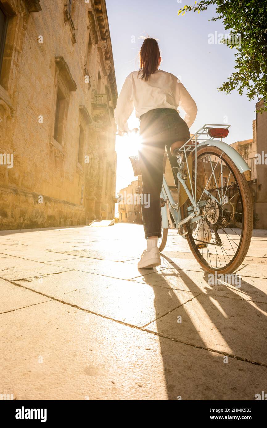 young woman seen from behind takes a bike ride in an city break Stock ...