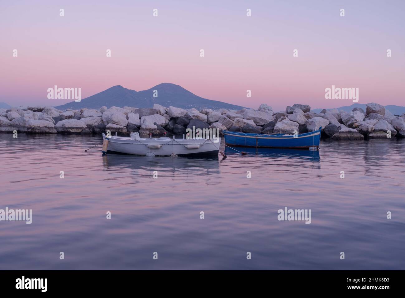 Tiny boates are docked in a calm port, in background Vesuvius Stock ...