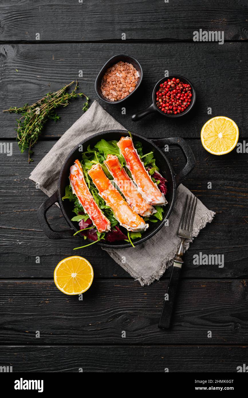 Delicious snow crab leg clusters set, on black wooden table background ...