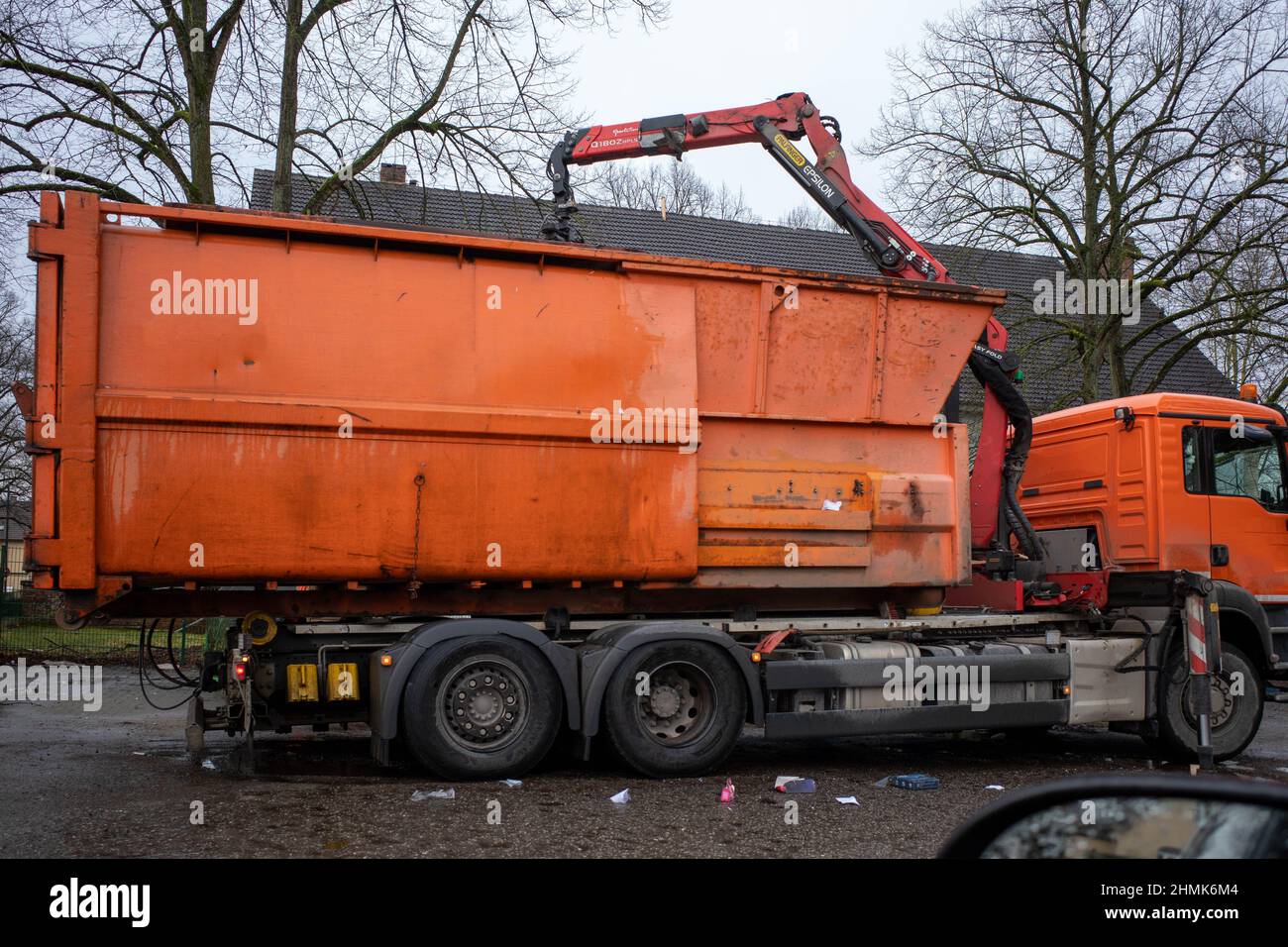 an orange garbage truck disposes of the garbage Stock Photo - Alamy
